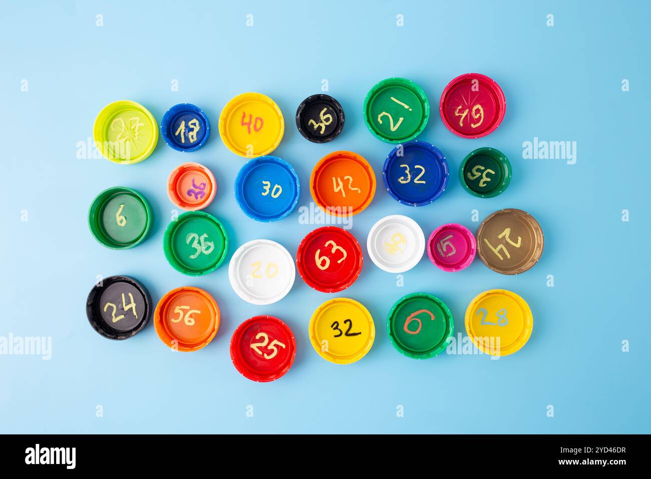 Colorful bottle caps with multiplication exercises on blue background ...