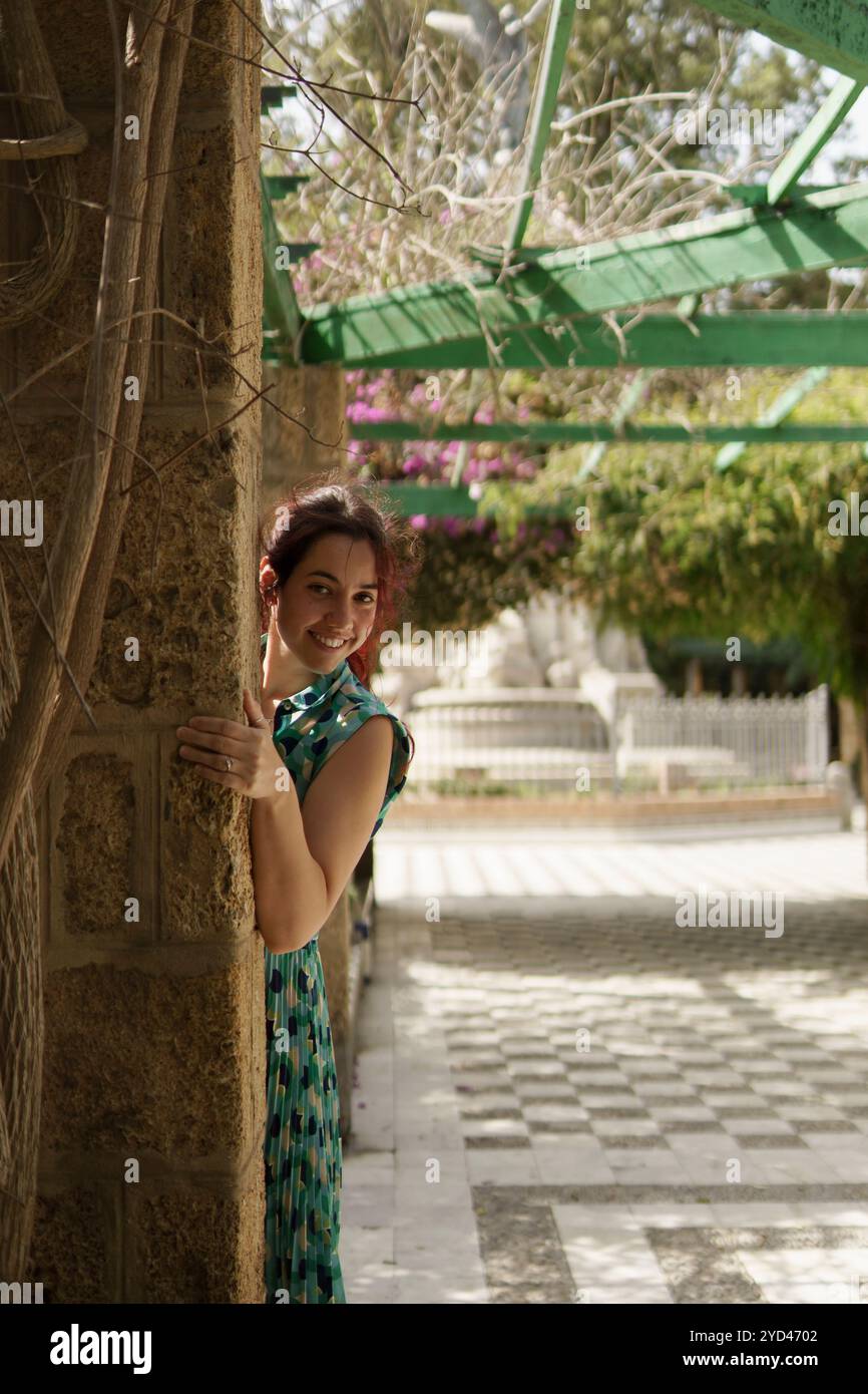 A smiling middle-aged woman peeks out behind a column Stock Photo - Alamy