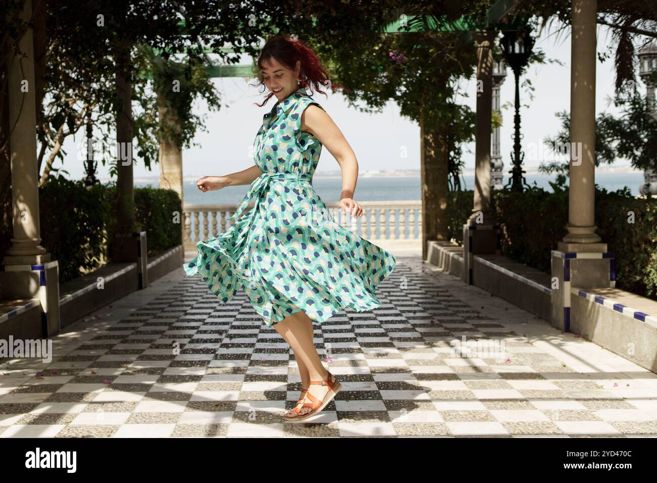 a smiling middle aged woman twirling in a green dress Stock Photo - Alamy
