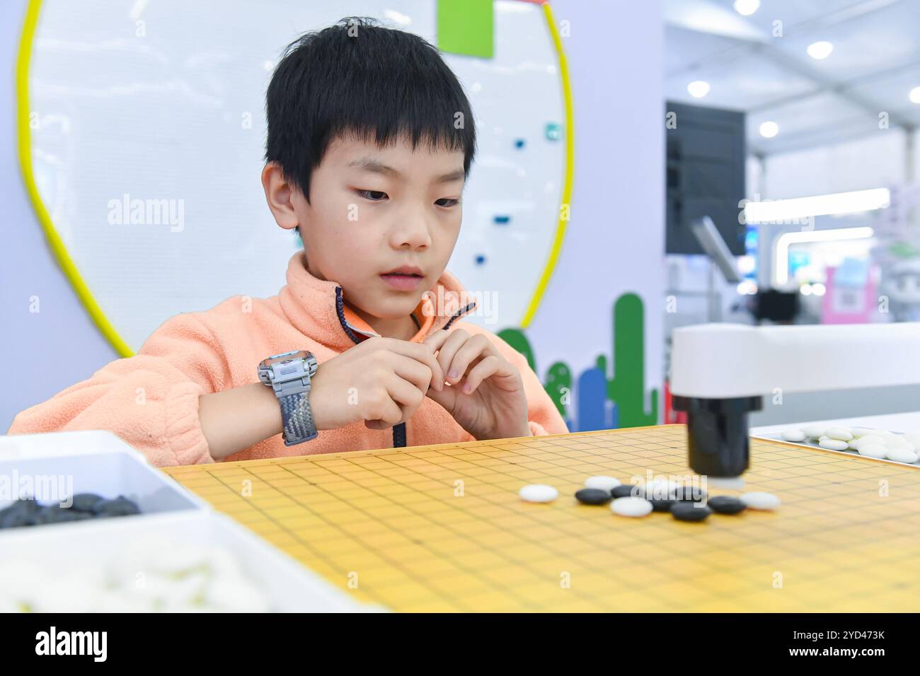 HEFEI, CHINA - OCTOBER 24, 2024 - A child plays with a Go robot at the ...