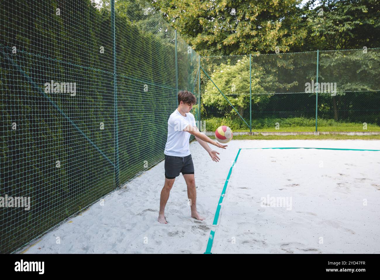Volleyball player practicing a bump pass on a sand court, focusing on ...
