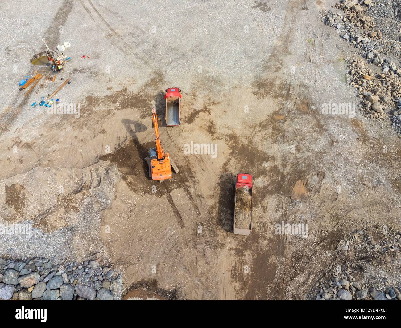 Aerial view of an excavator loading sand into a truck on a sunny day ...