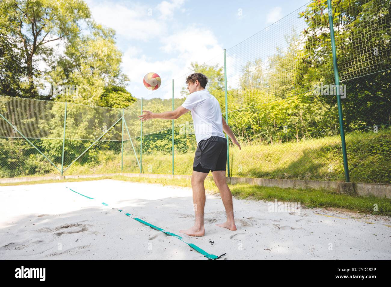 Volleyball player practicing a bump pass on a sand court, focusing on ...