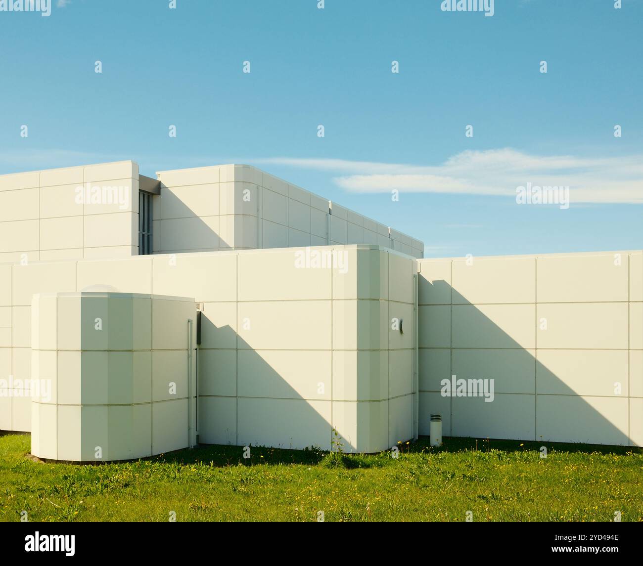 Facade of modern building with elevated concrete tiles on lawn Stock ...