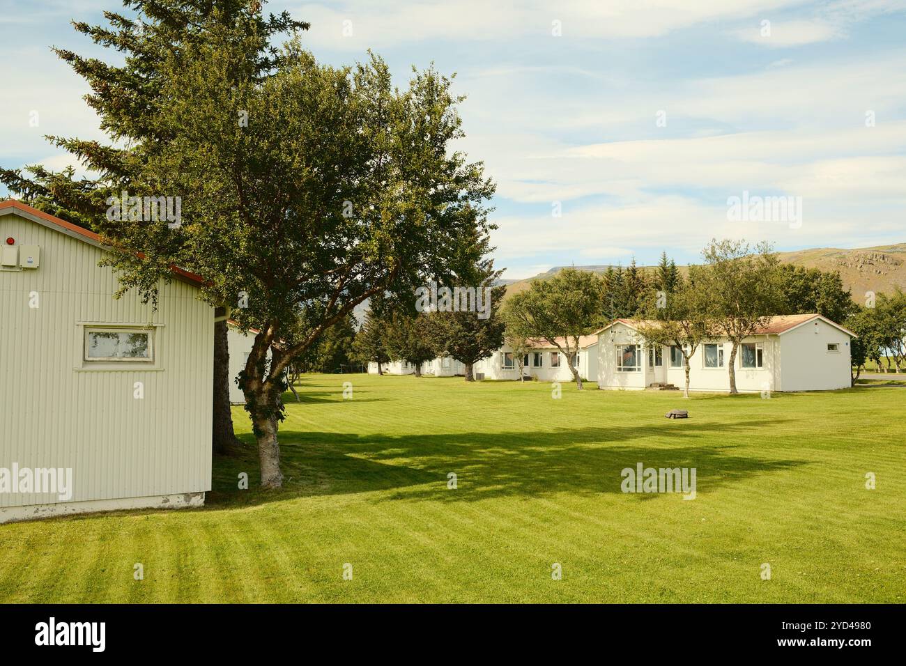 Simple dwelling houses built on green meadow Stock Photo - Alamy