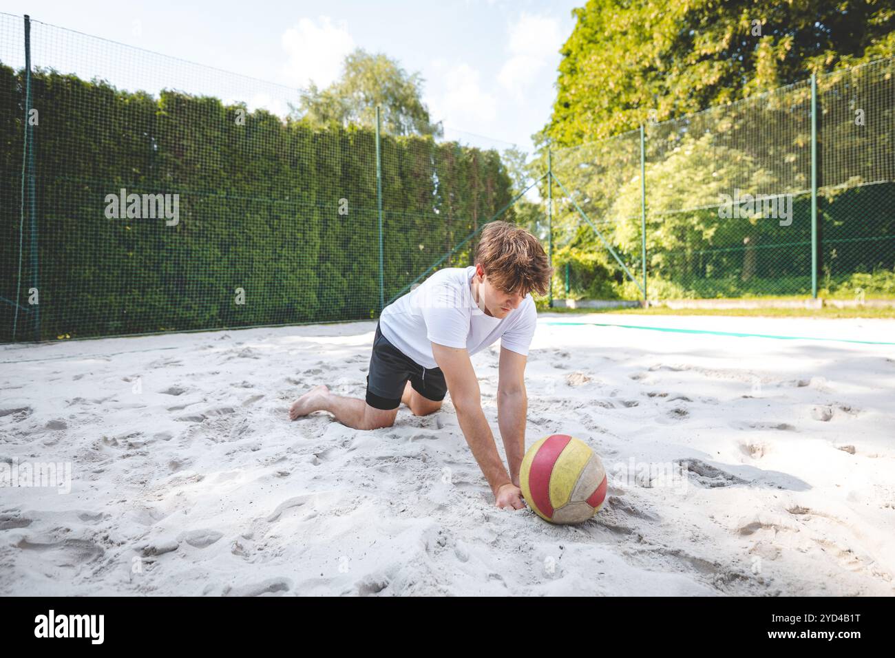 Volleyball player is digging volleyball ball on a sandy court ...