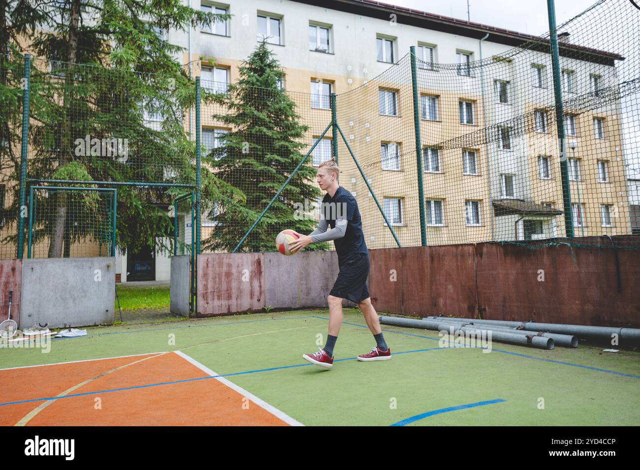 Volleyball player is serving on a hard court during an outdoor game ...