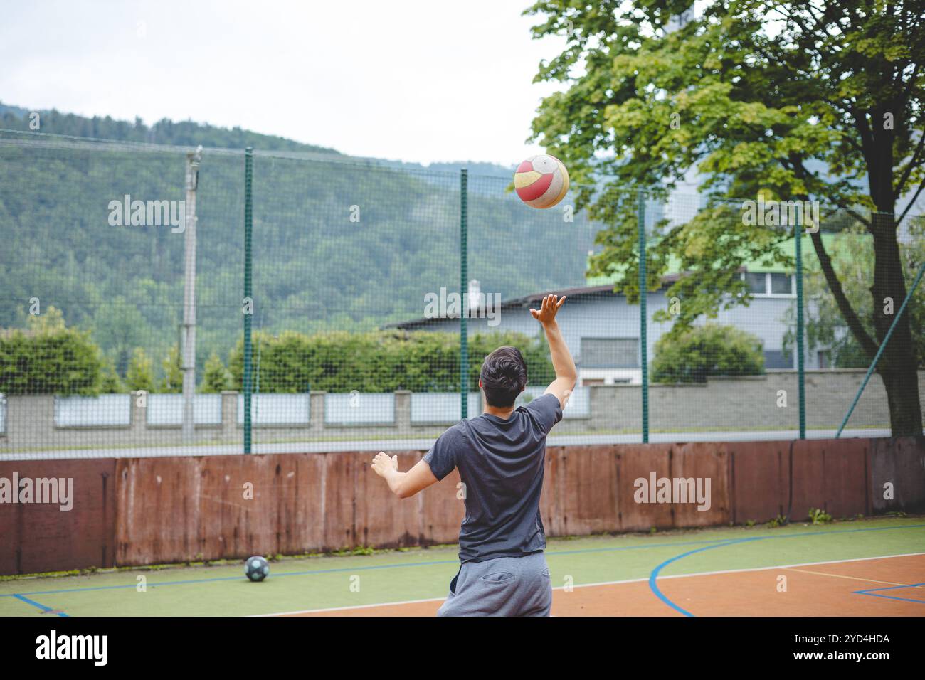 Volleyball player practicing ball control on a hard court, focusing on ...