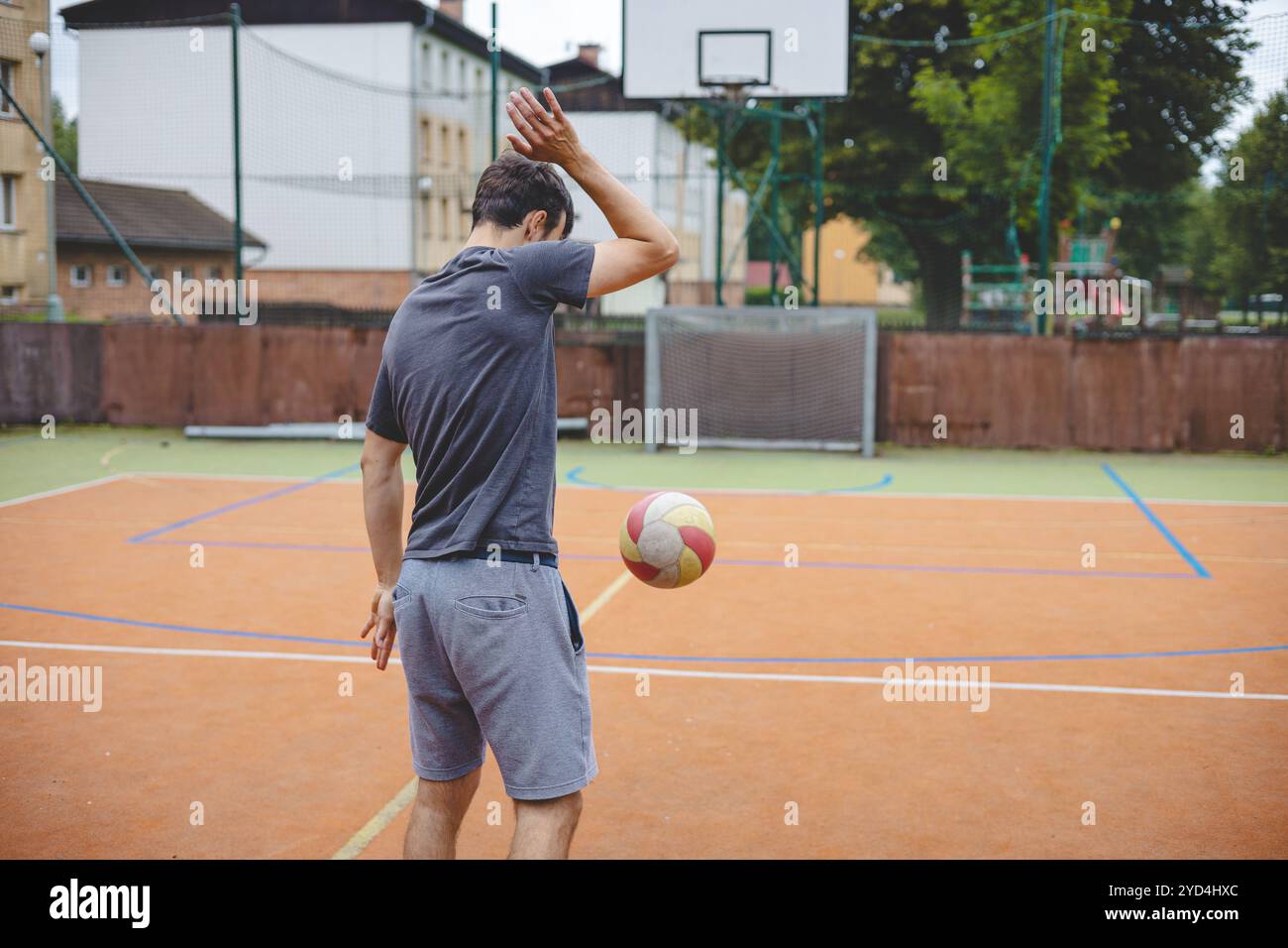 Volleyball player practicing ball control on a hard court, focusing on ...