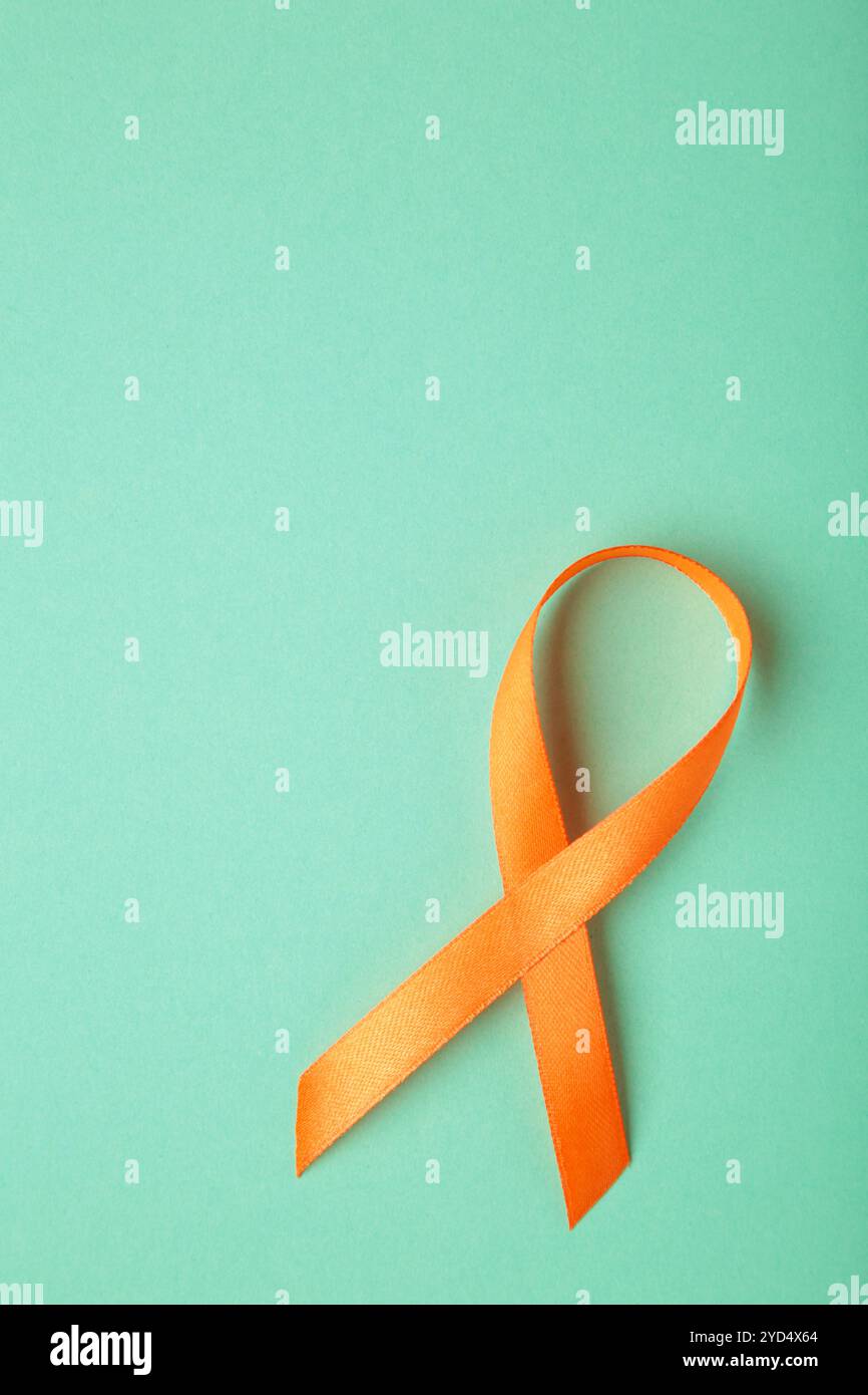 Orange ribbon on mint background . Healthcare and medicine concept ...