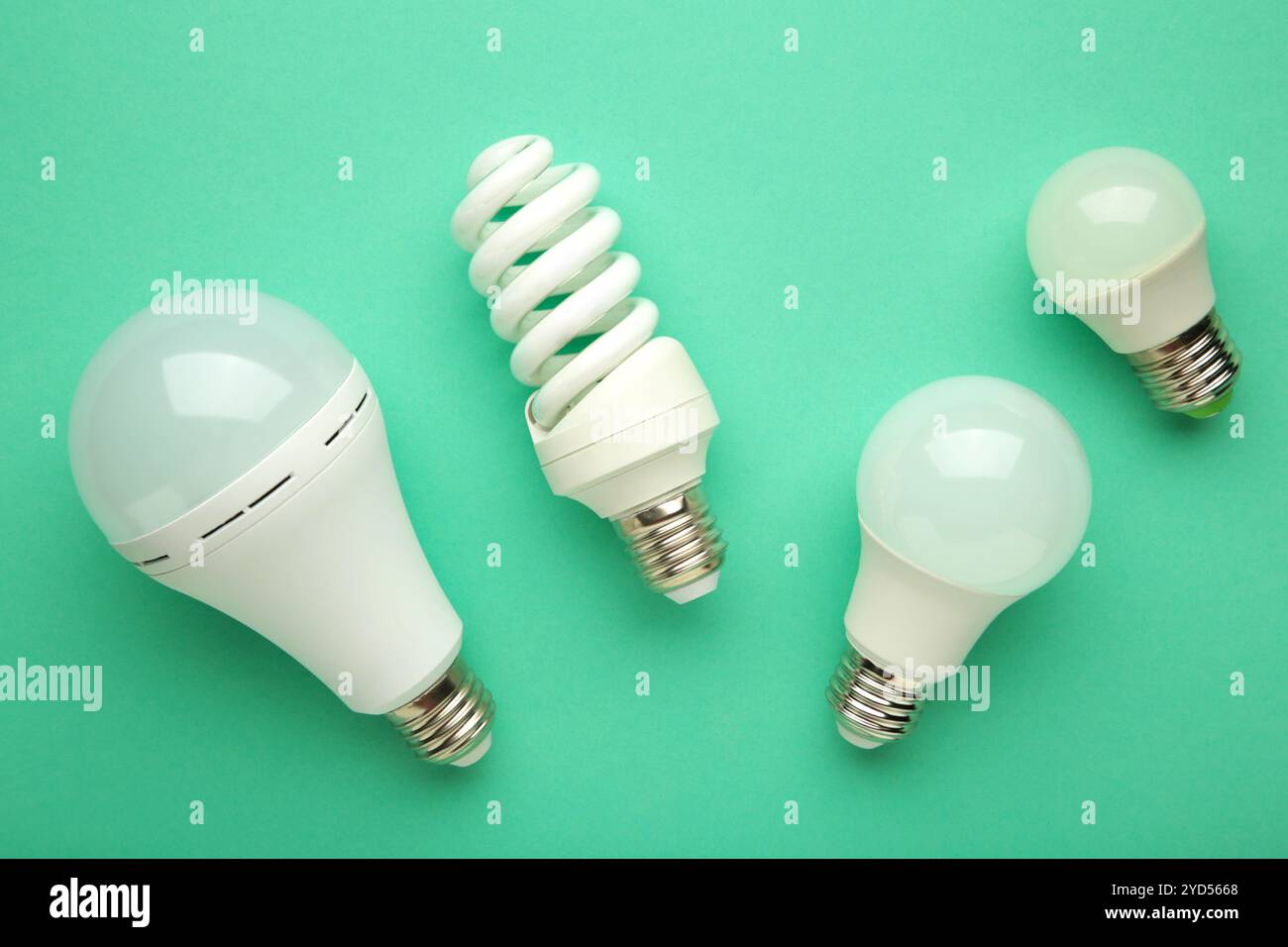 Comparison of different light bulbs on mint background. Top view Stock ...