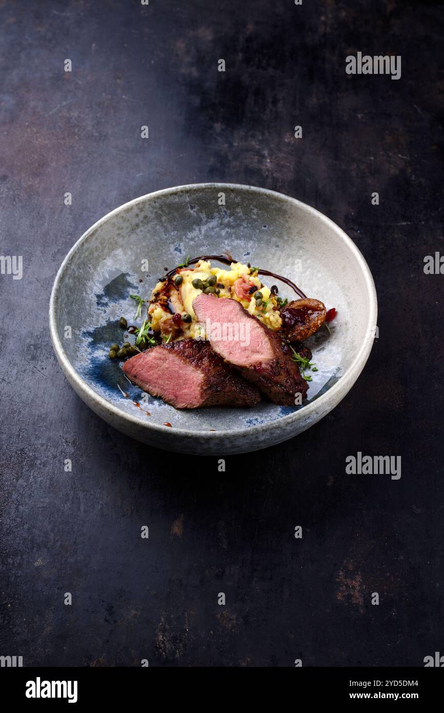 Traditional fried wild hare back filet with plums Stock Photo - Alamy