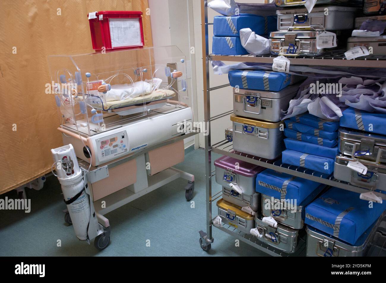 A neonatal intensive care unit (NICU) with a baby in an incubator and ...