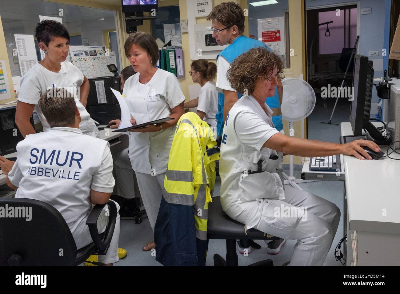 A hospital ward with medical staff working together to care for ...