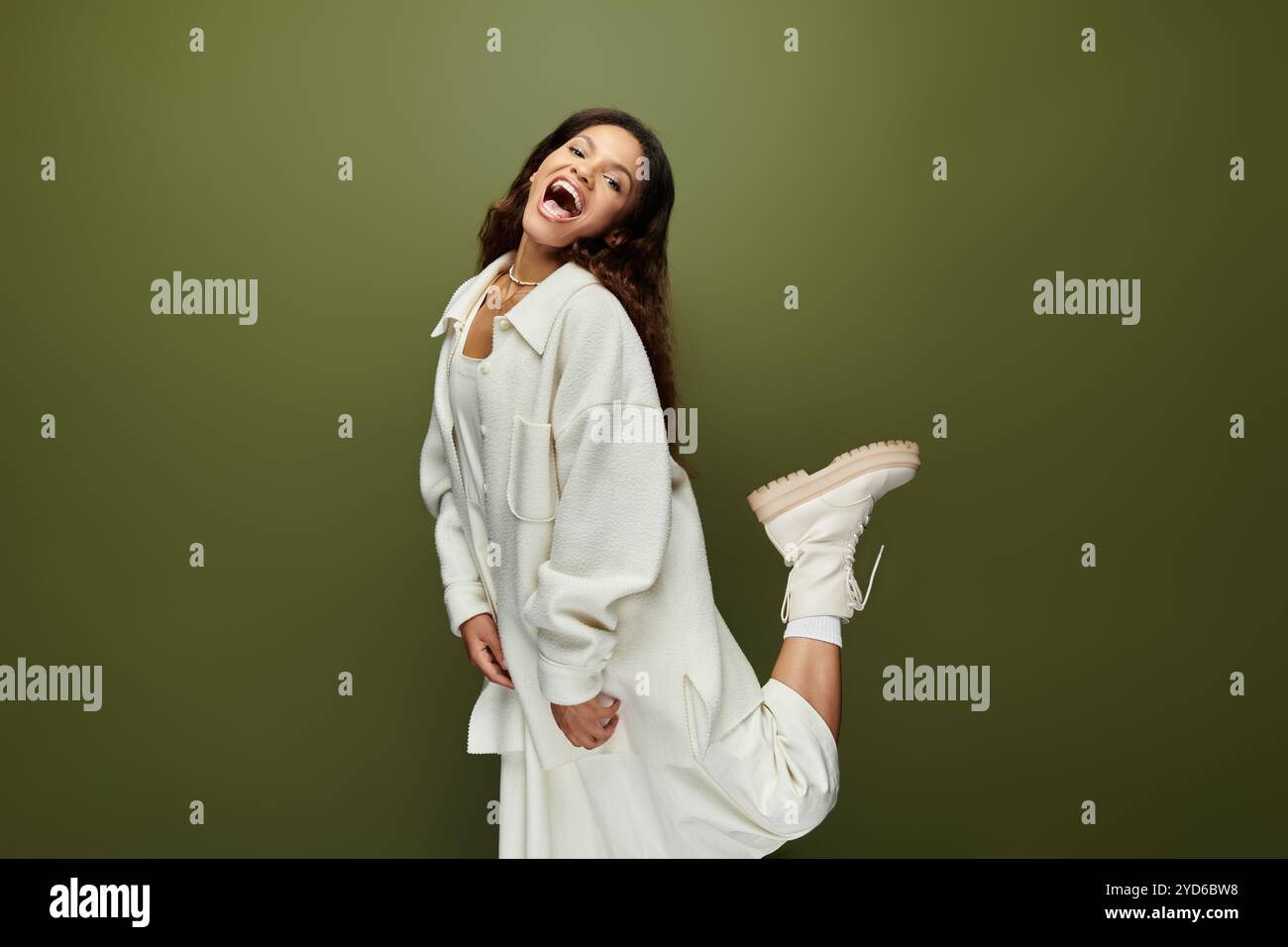 A carefree woman with a bright smile playfully poses, showcasing her ...