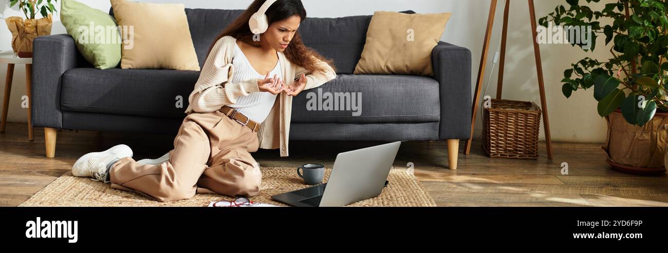 Seated comfortably on the floor, a woman explores her laptop with ...