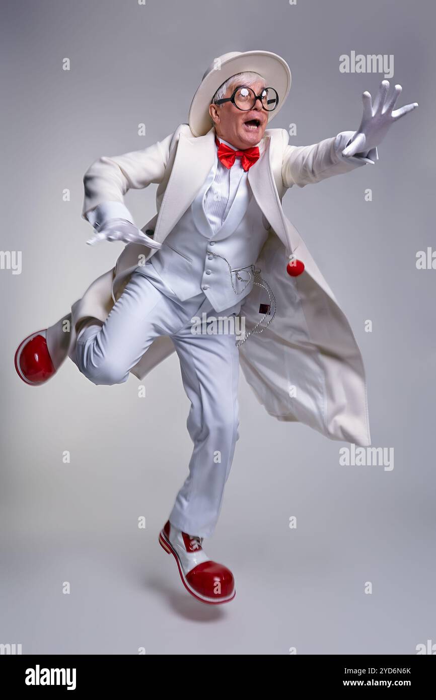 The clown is in a hurry, running and jumping. An elderly clown in a ...