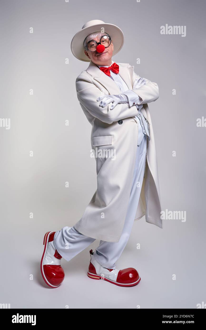 Ð¡lown in a white coat, hat and large red patent leather clown boots ...