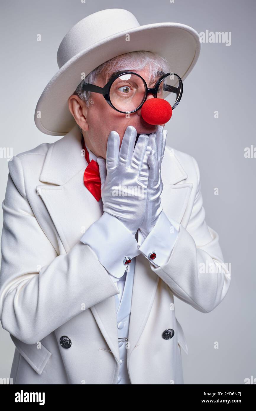 Surprised clown with gloved hands near his face Stock Photo - Alamy
