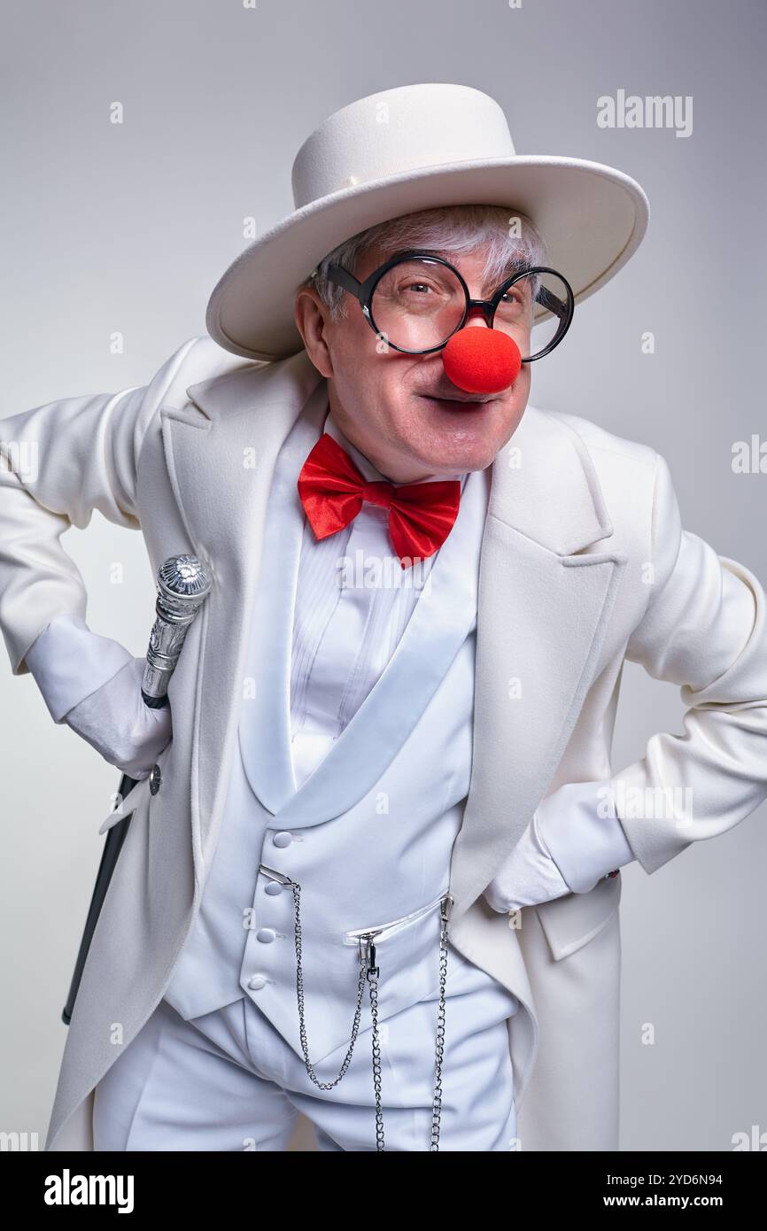 Ð¡lown in a white coat and hat with walking stick with a cocky ...