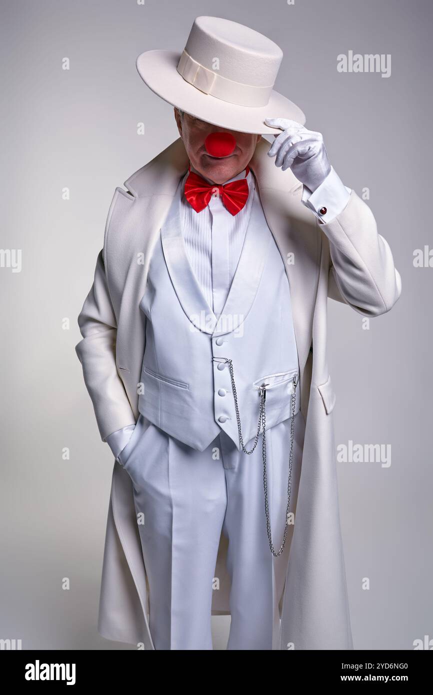 An elderly serious mafia-like clown in a white coat and hat. Right hand ...