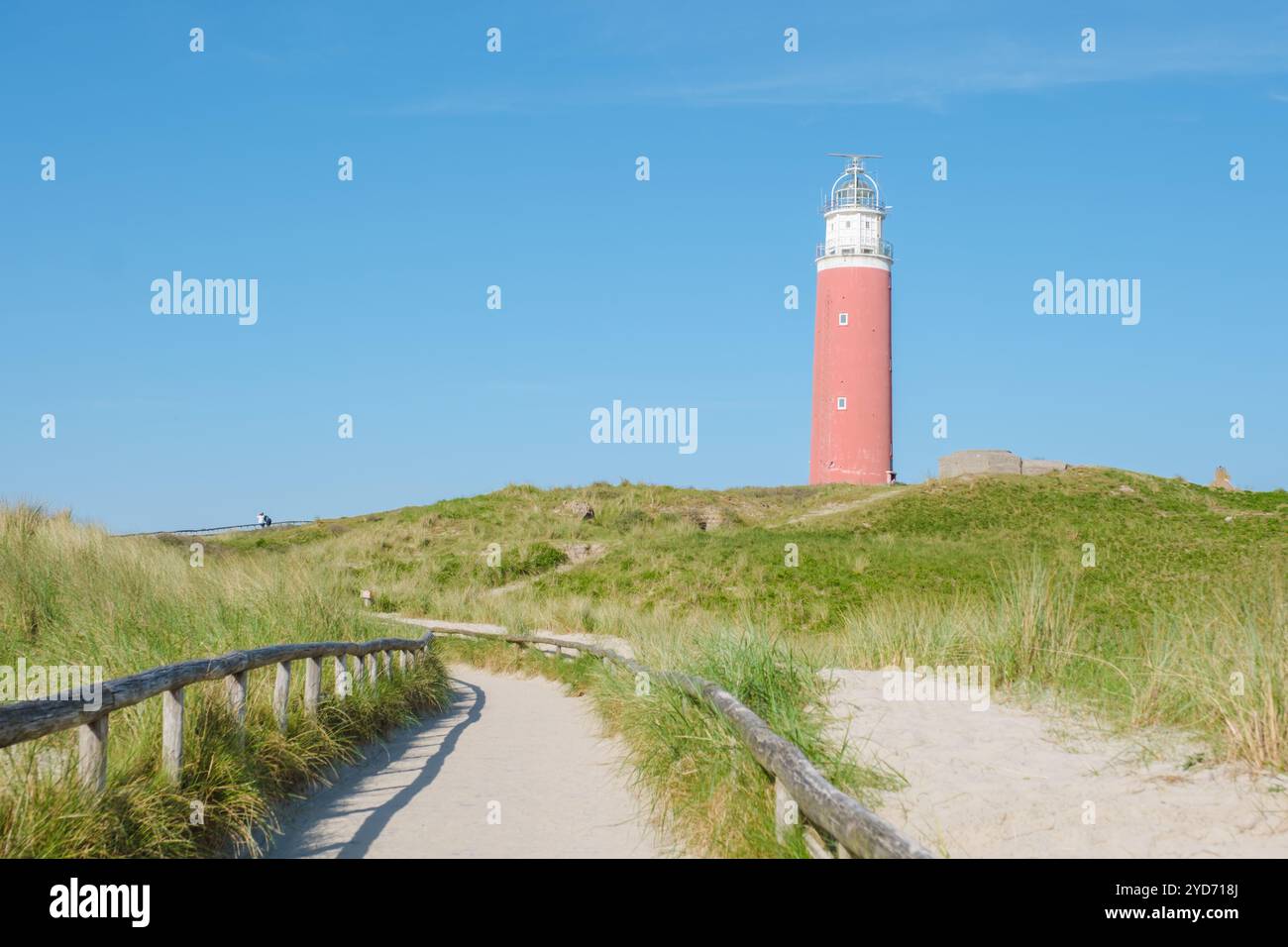 A winding path through the sandy dunes leads to a majestic lighthouse ...