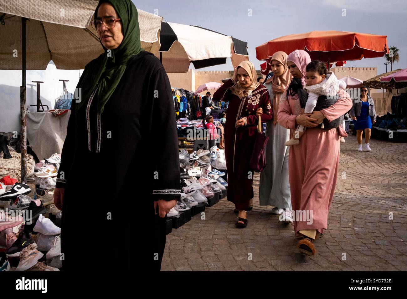 Veiled woman with a child whose mother she is in the souk market of the ...