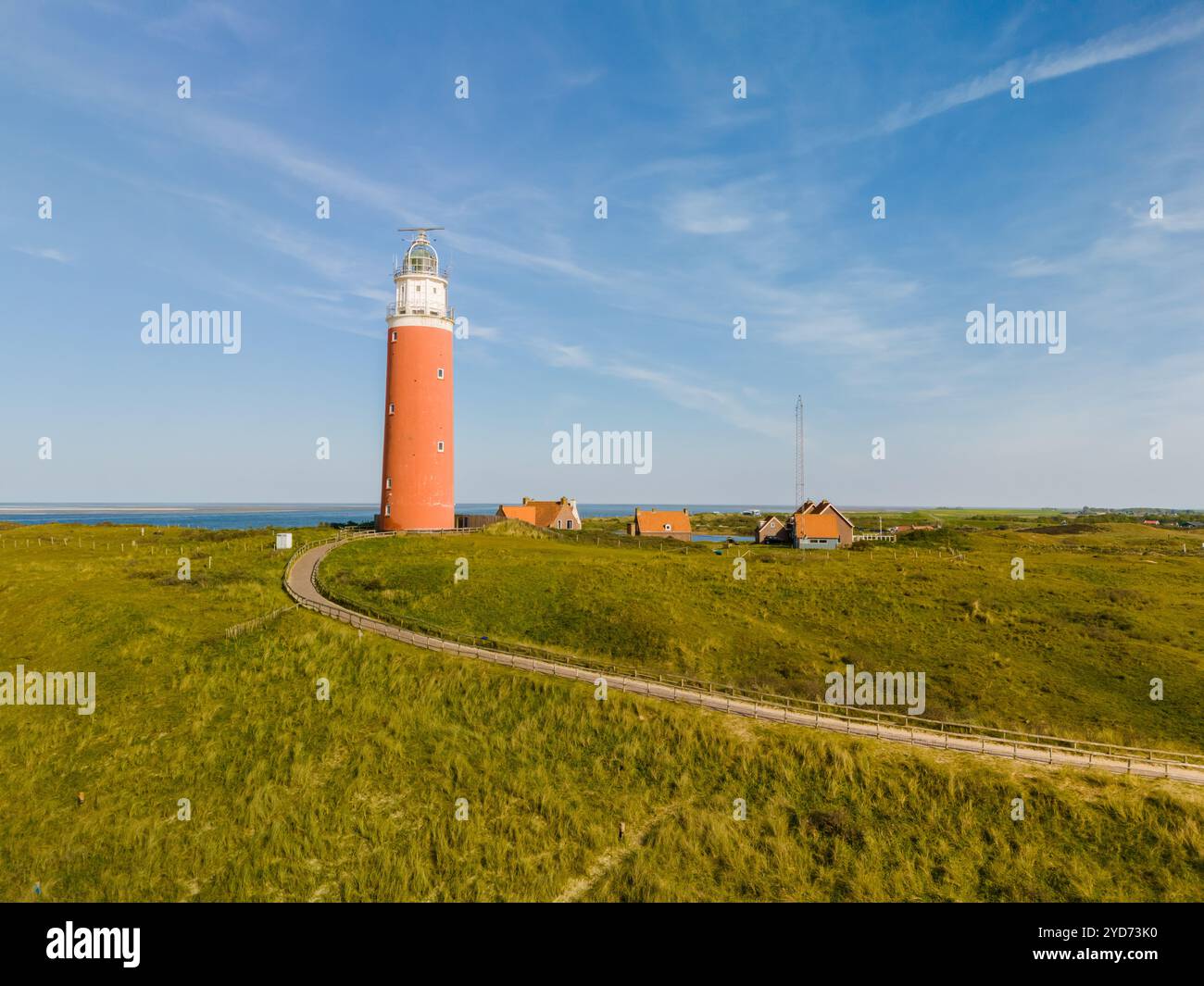 A majestic lighthouse stands tall on a grassy field, casting a watchful ...