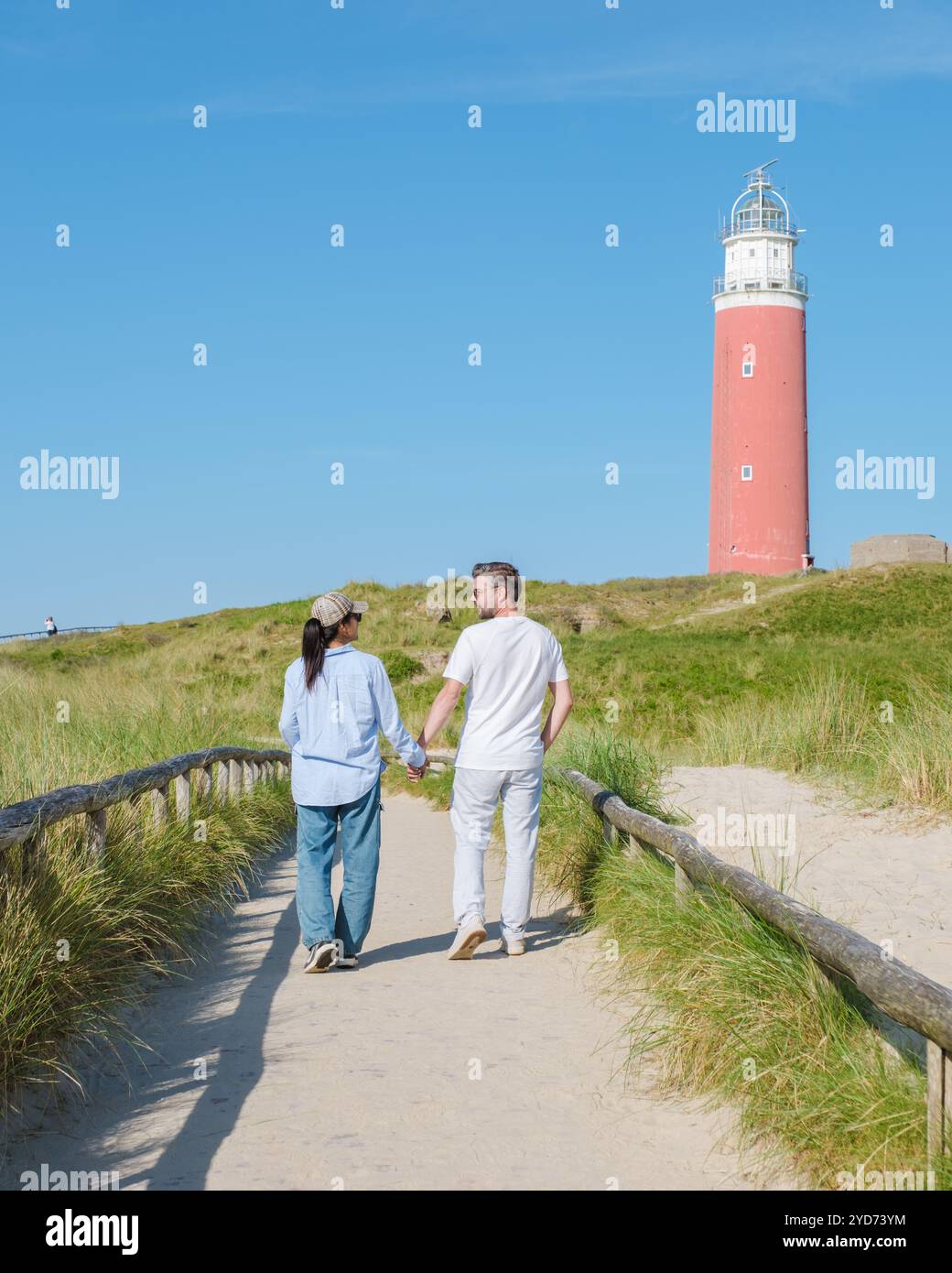 A couple strolls hand in hand on a winding path, gazing out at the ...