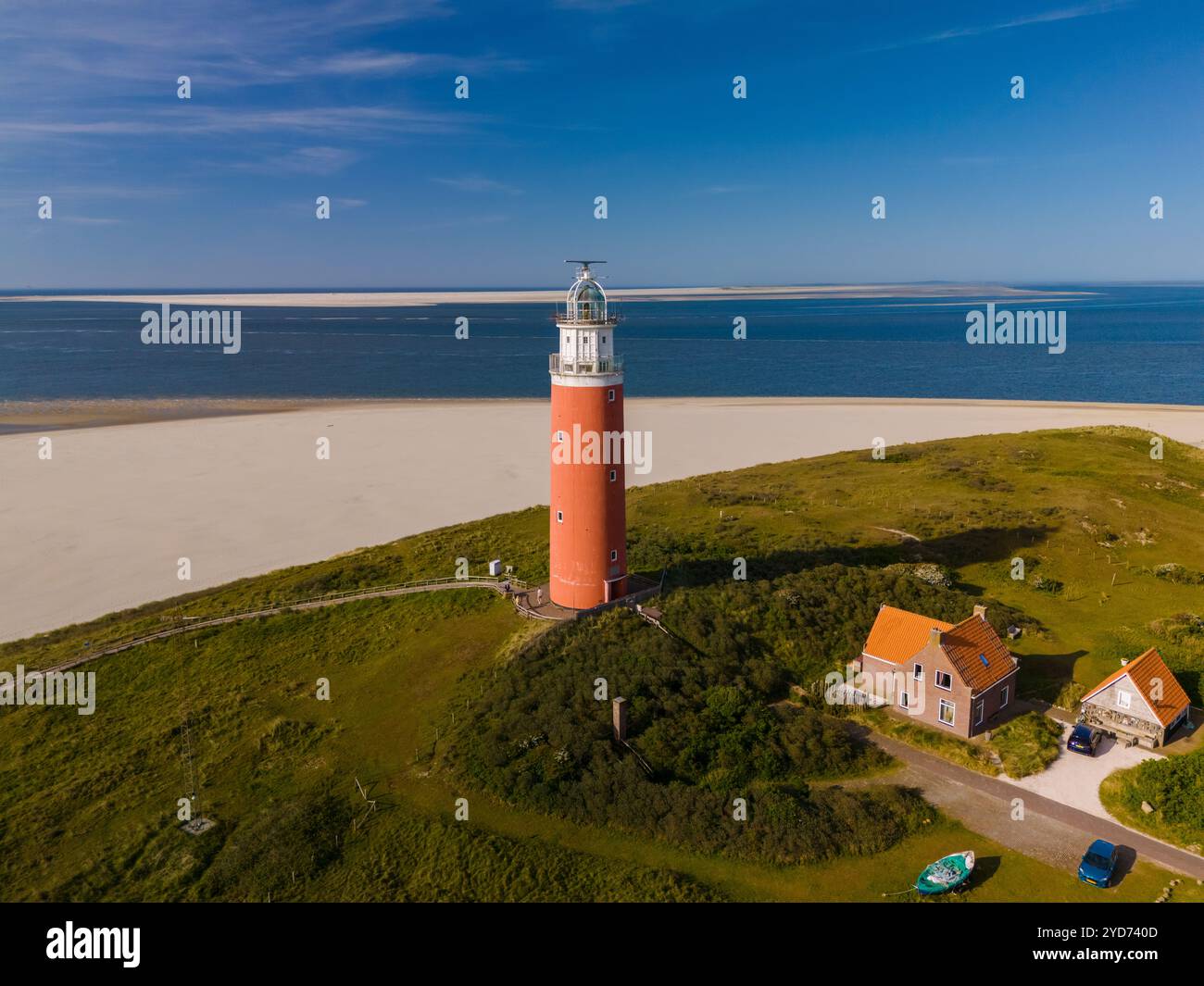 A majestic lighthouse stands tall on a sandy beach, overlooking the ...