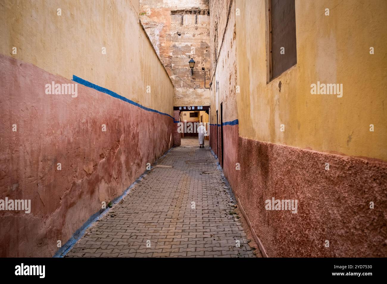 Moroccan man in traditional dress walking in the medina of the city of ...