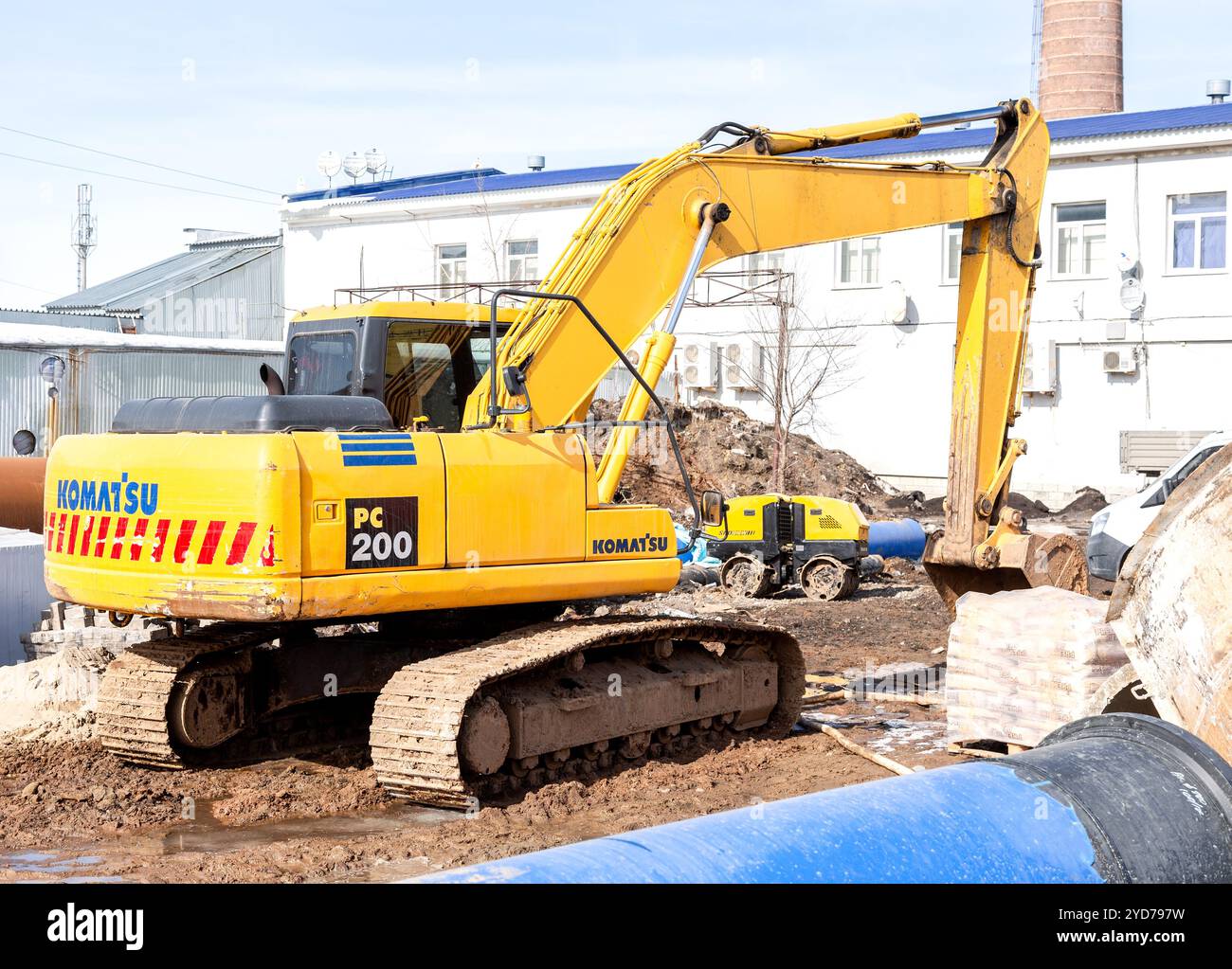 An excavator is working on a construction site to lay large diameter ...