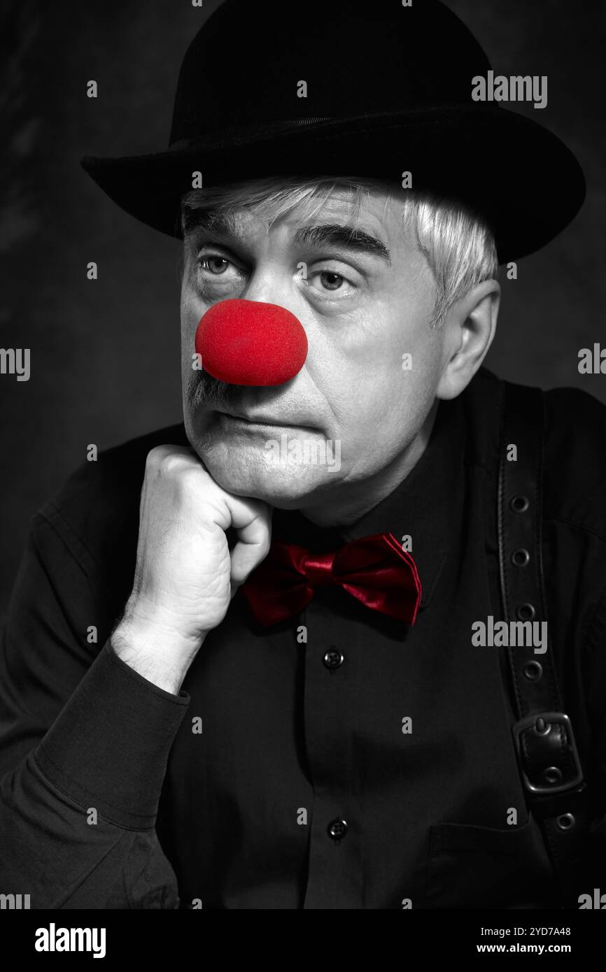 Dramatic selective color portrait of a sad clown against a dark ...