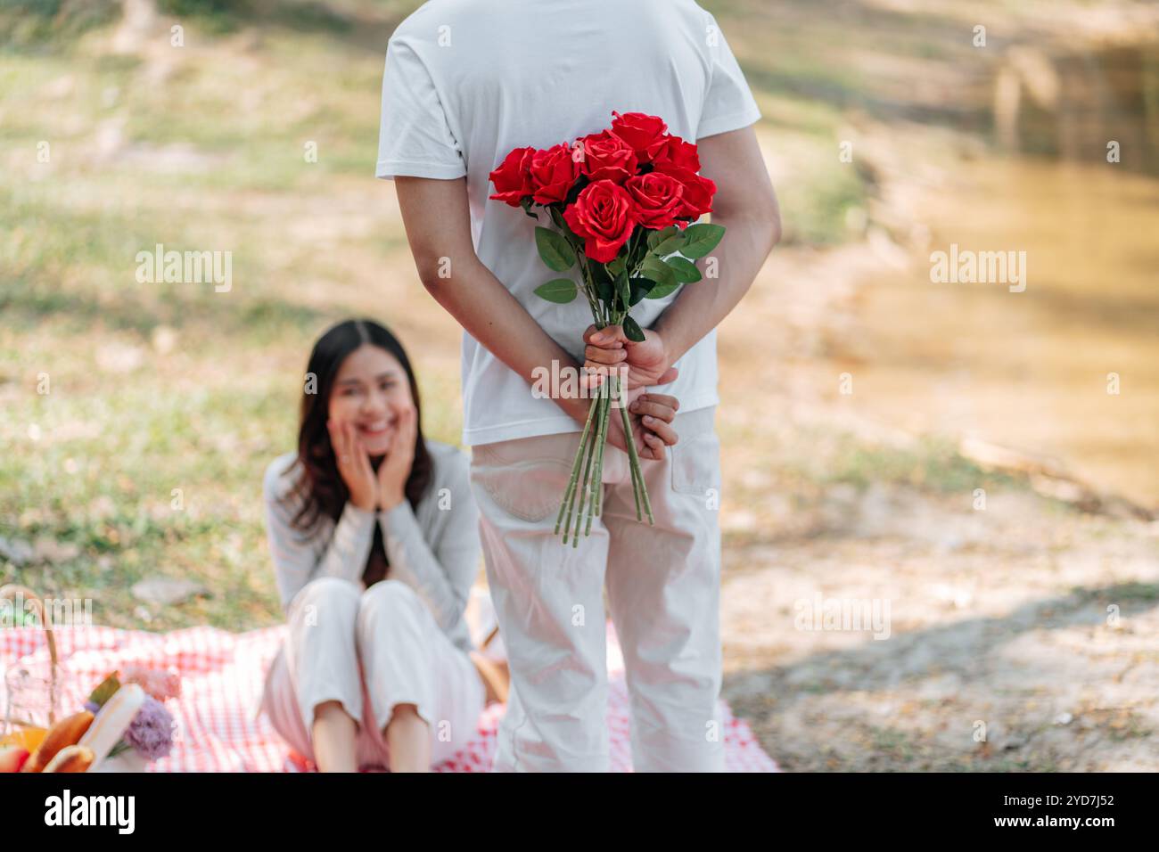 Happy romantic couple in Valentine's Day asian man hiding red rose ...