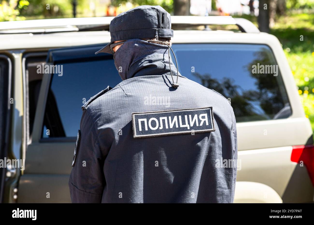 Special Forces police officer in black uniform near a patrol car in ...