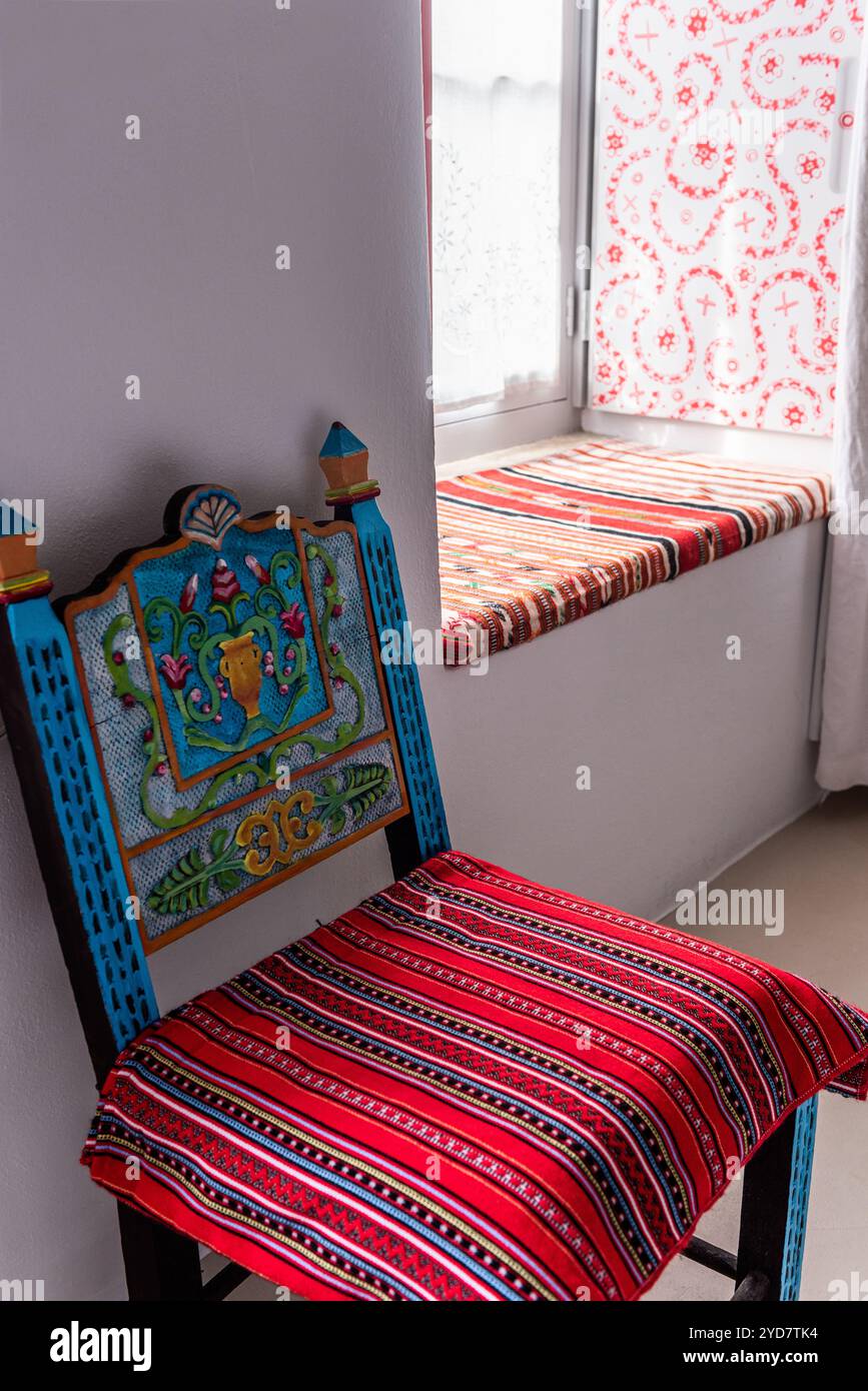 Traditional Greek chair and fabrics in window of historic house on the ...