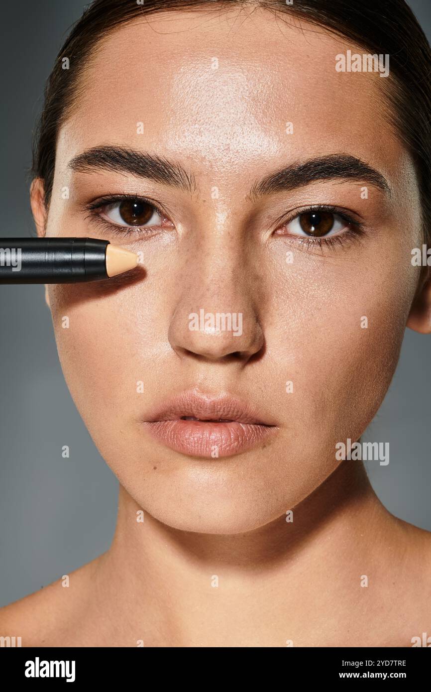 A beautiful woman artistically enhances her features with a makeup ...