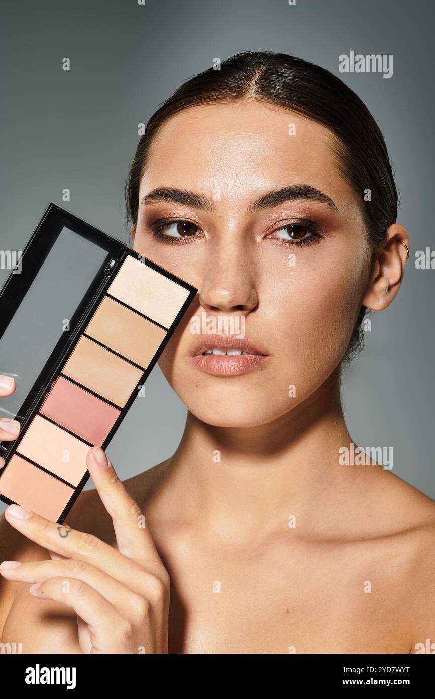 A stunning woman displays her makeup palette, highlighting her graceful ...