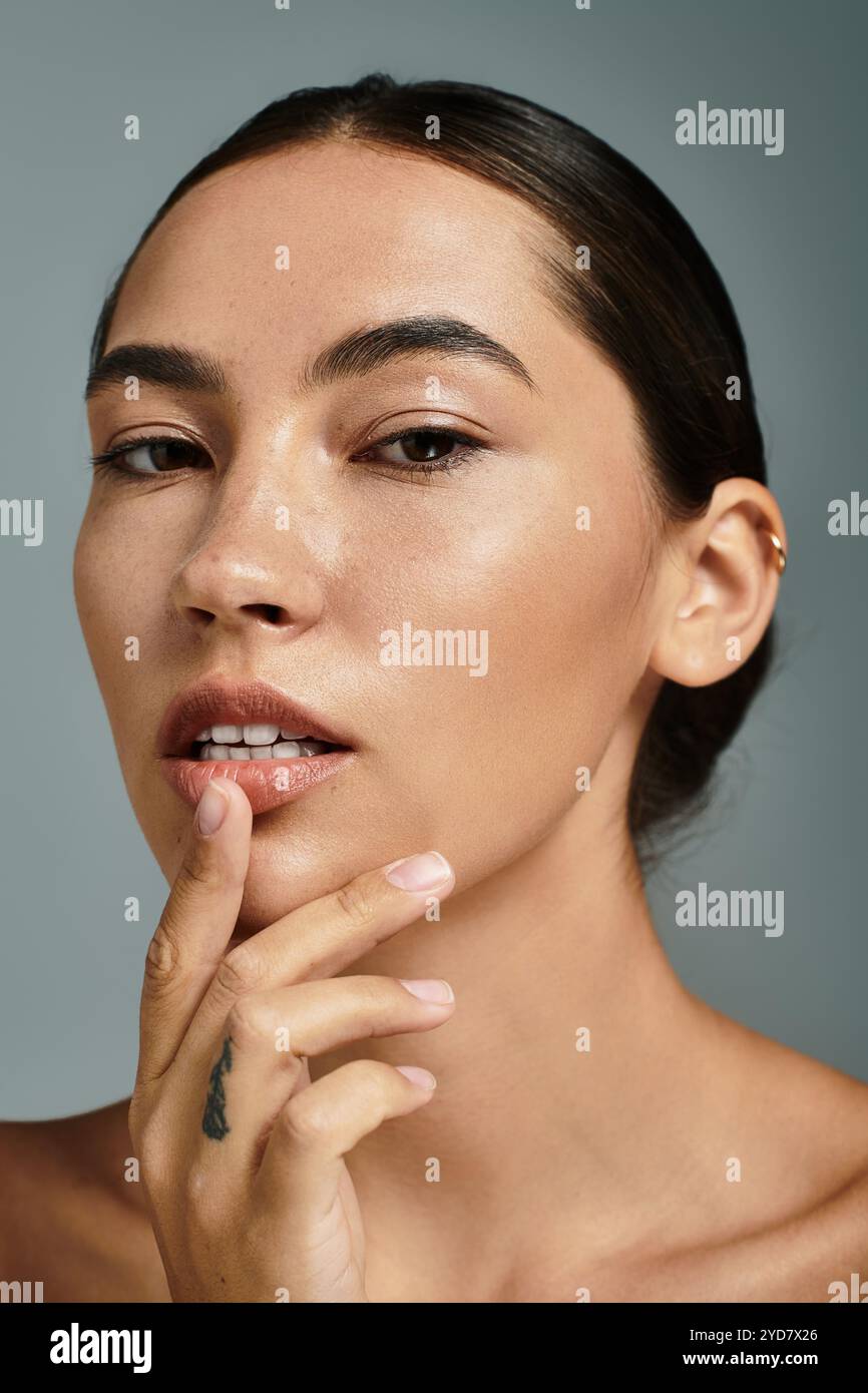 A stunning woman showcases her beauty and poise, gently touching her ...