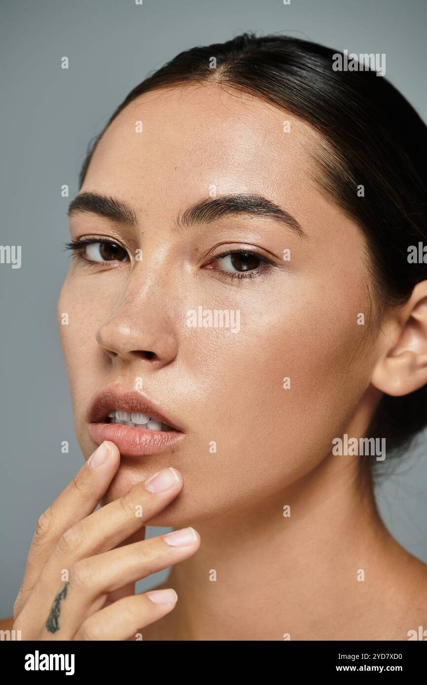 A woman gazes thoughtfully, highlighting her striking features and ...