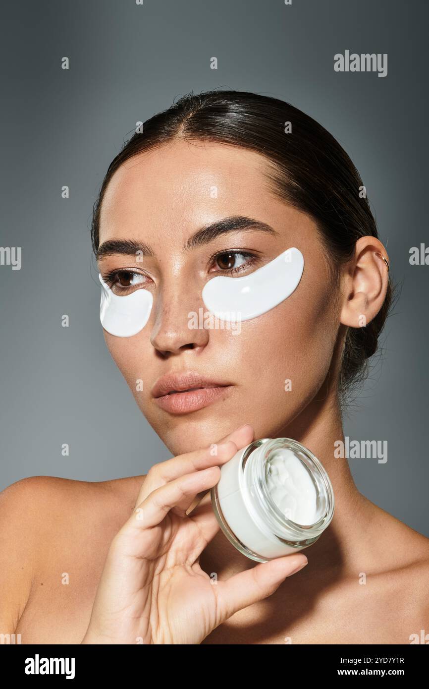 In a calming atmosphere, a beautiful woman focuses on her skincare ...