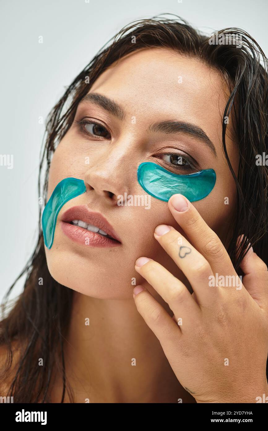 The woman enjoys a moment of self care with soothing gel eye patches ...
