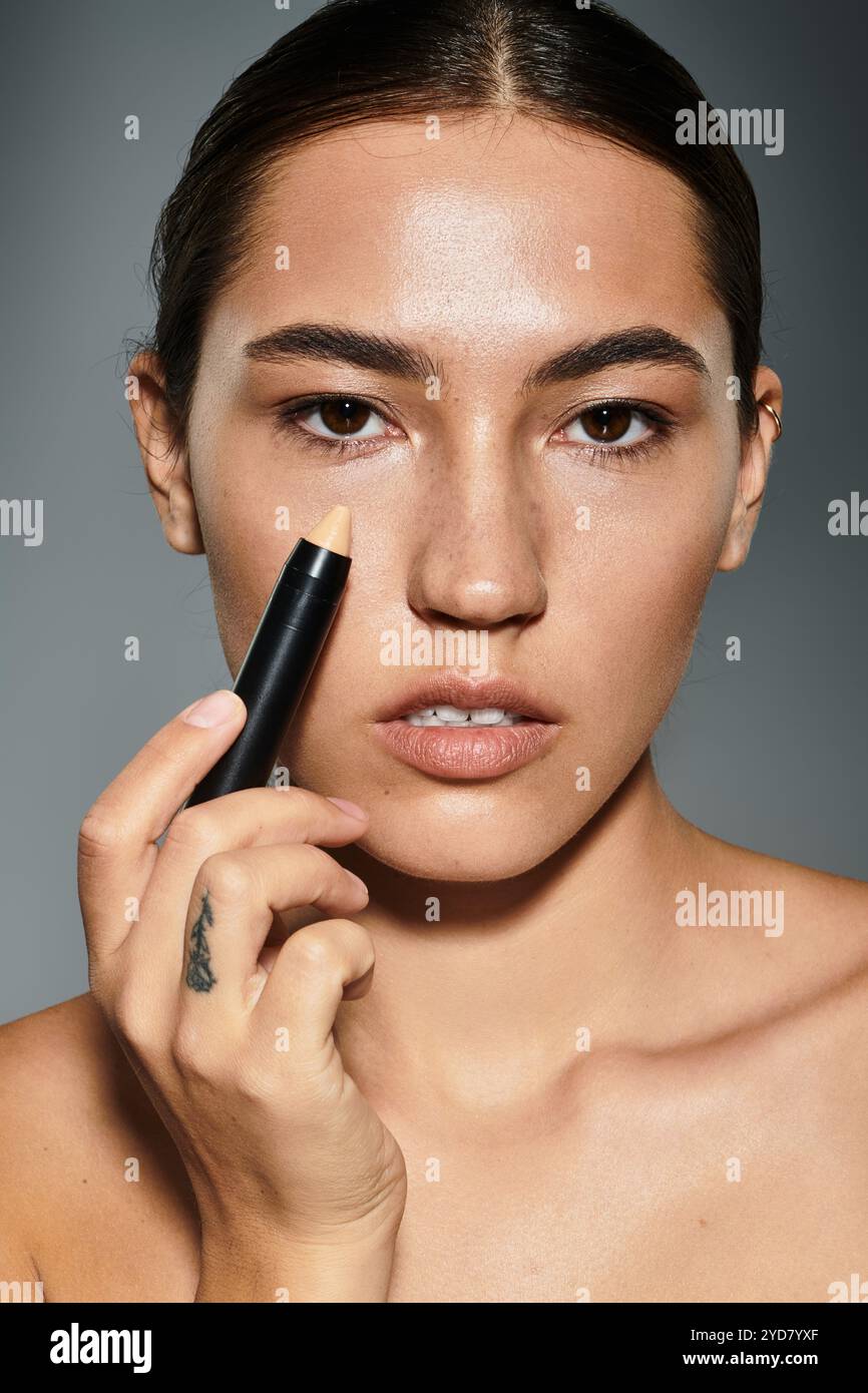 The woman skillfully enhances her features while applying makeup with ...