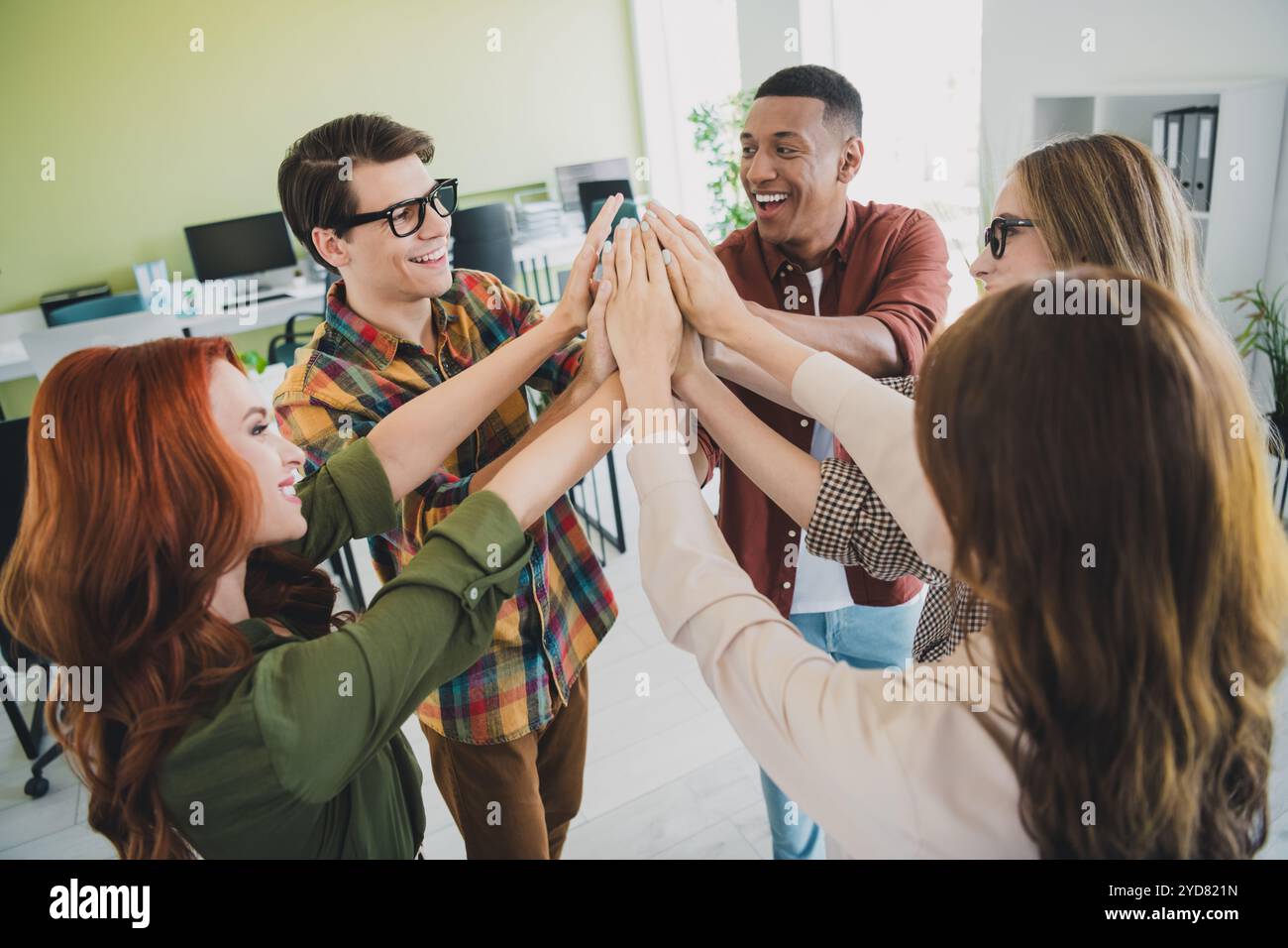 Portrait of young successful colleagues pile stack arms collaborate ...