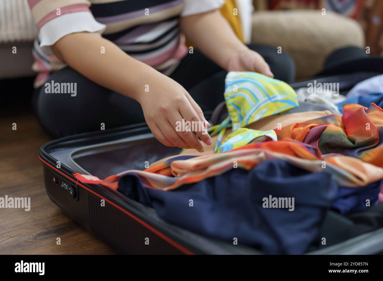 Woman packs baggage in suitcase for new journeyÂ packing a luggage ...