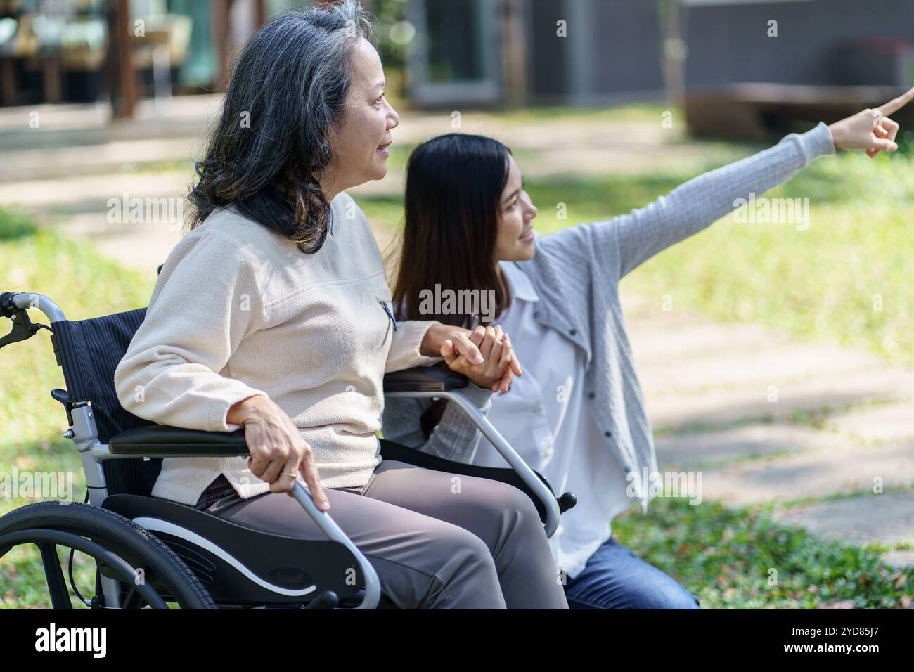 Asian senior woman in wheelchair with happy daughter. Family relationship retired woman sitting ...