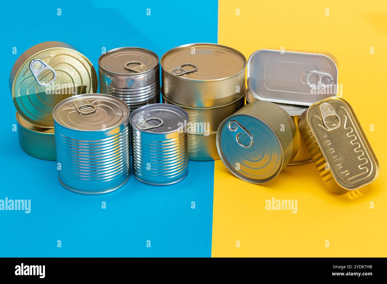 A Group of Stacked Tin Cans on Split Blue and Yellow Background. Canned ...