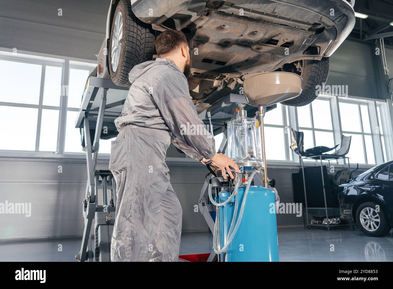 Car Mechanic Replacing Oil in Motor Engine. Auto service shop Stock ...