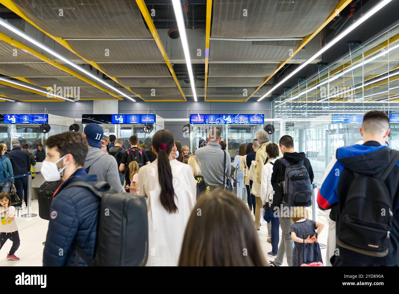 Crowd of travelers patiently waiting in line at a busy airport check-in ...