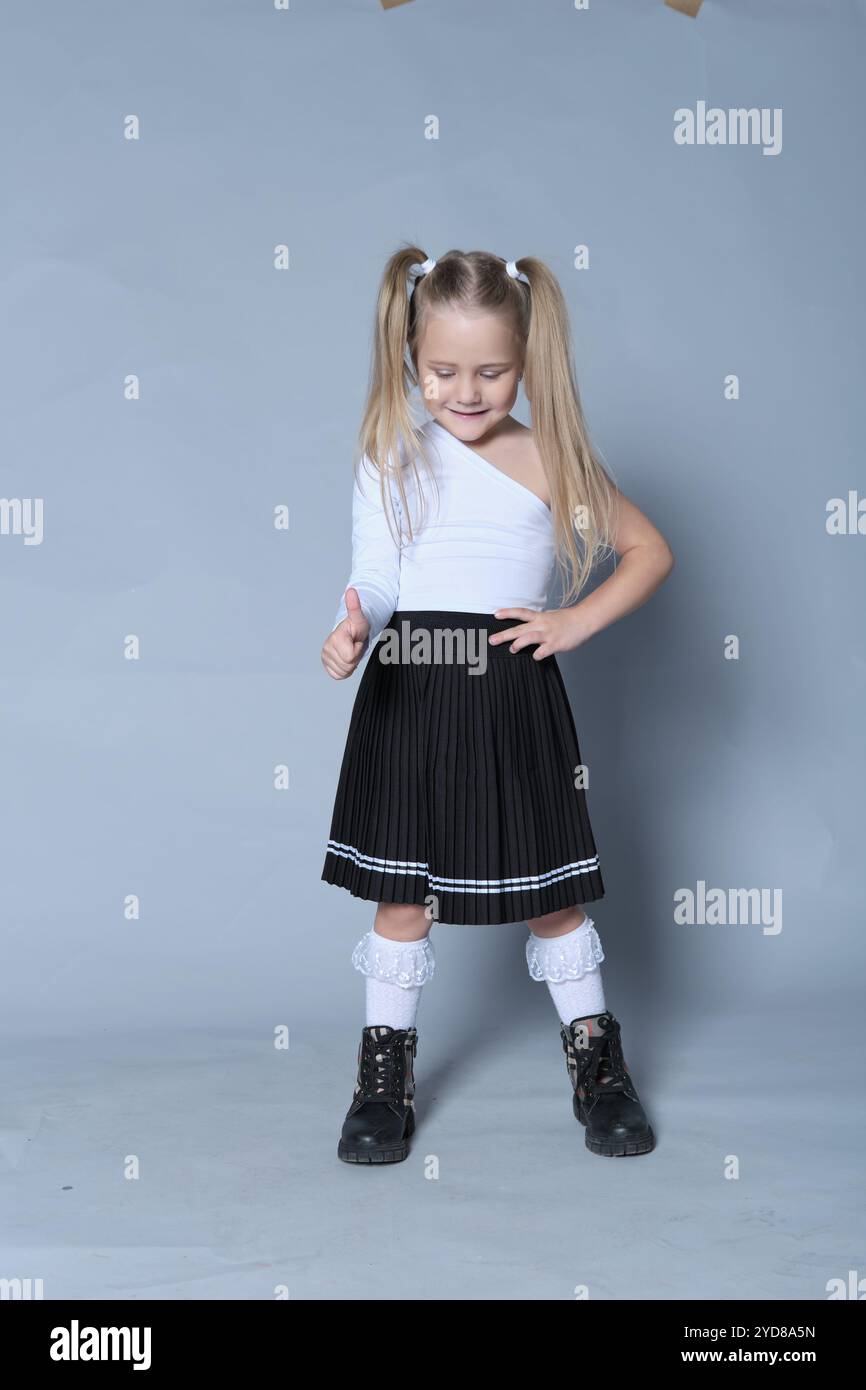 This adorable girl strikes a fun and confident pose in a modern outfit ...